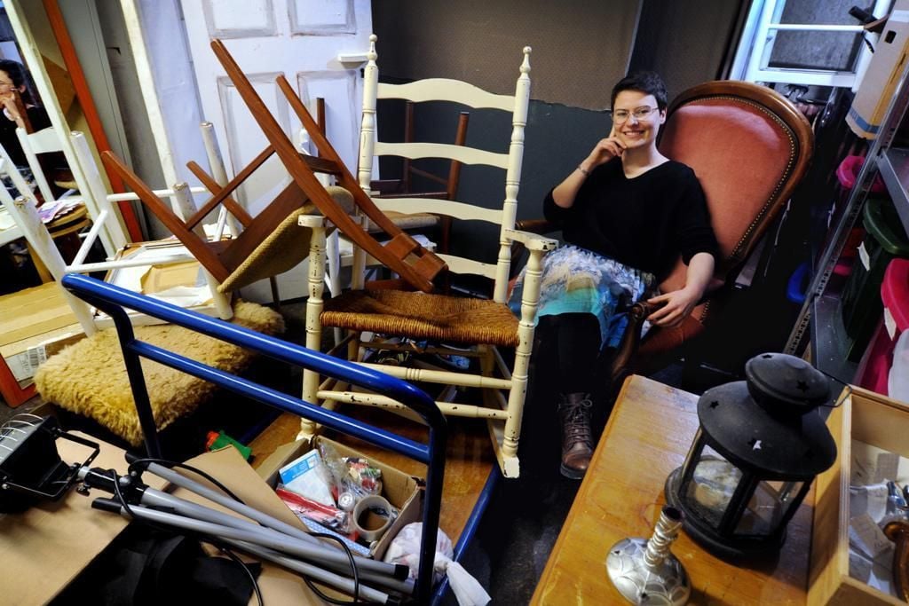 Elisabeth Ebert, Leiterin der „English Drama Group“ der Uni. inmitten der Requisiten: In großen Kisten lagern Kostüme, es gibt Stühle, Tischchen, Lampen, Koffer, Spiegel – und ein großes gelbes Sofa.