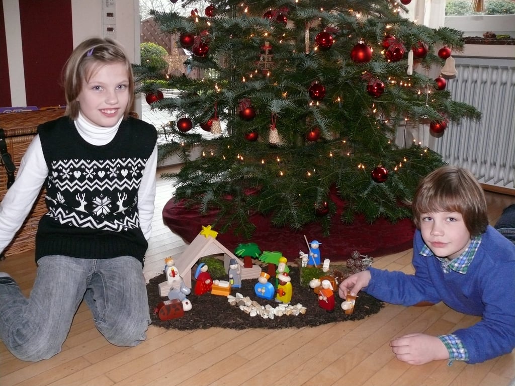 Jule und Luca Petermann spielen mit den Figuren / Kerzen sorgen für ...
